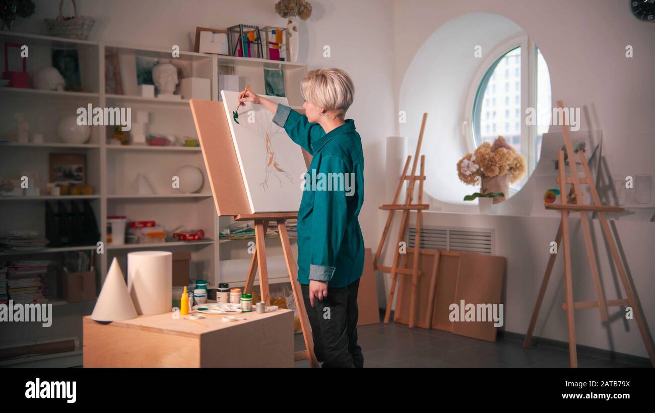 A young woman artist coloring her painting Stock Photo - Alamy
