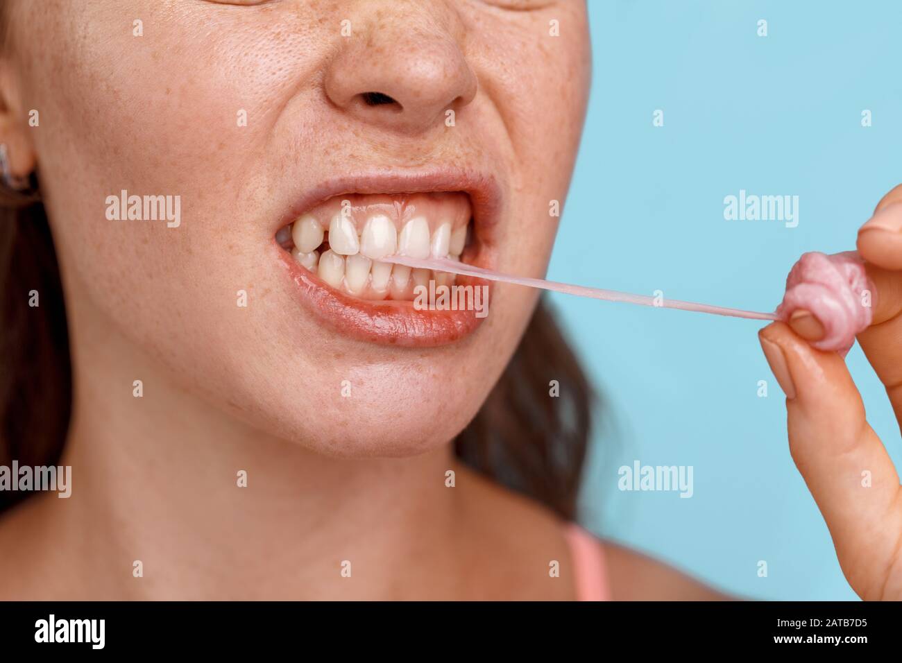 Summer Freestyle. Young woman with freckles standing isolated on blue ...