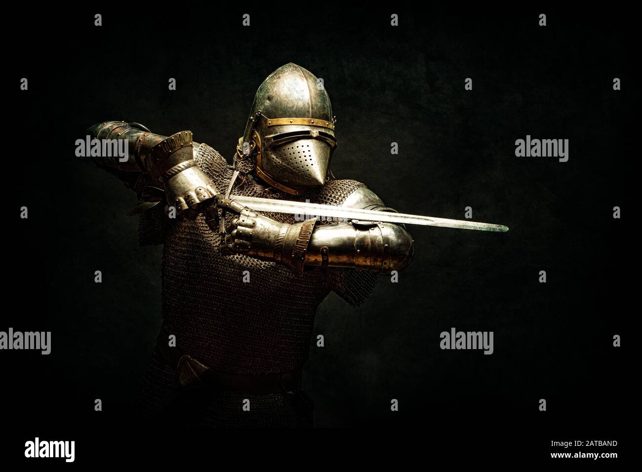 Portrait of a knight in armor, his sword in his hands, performing an ...