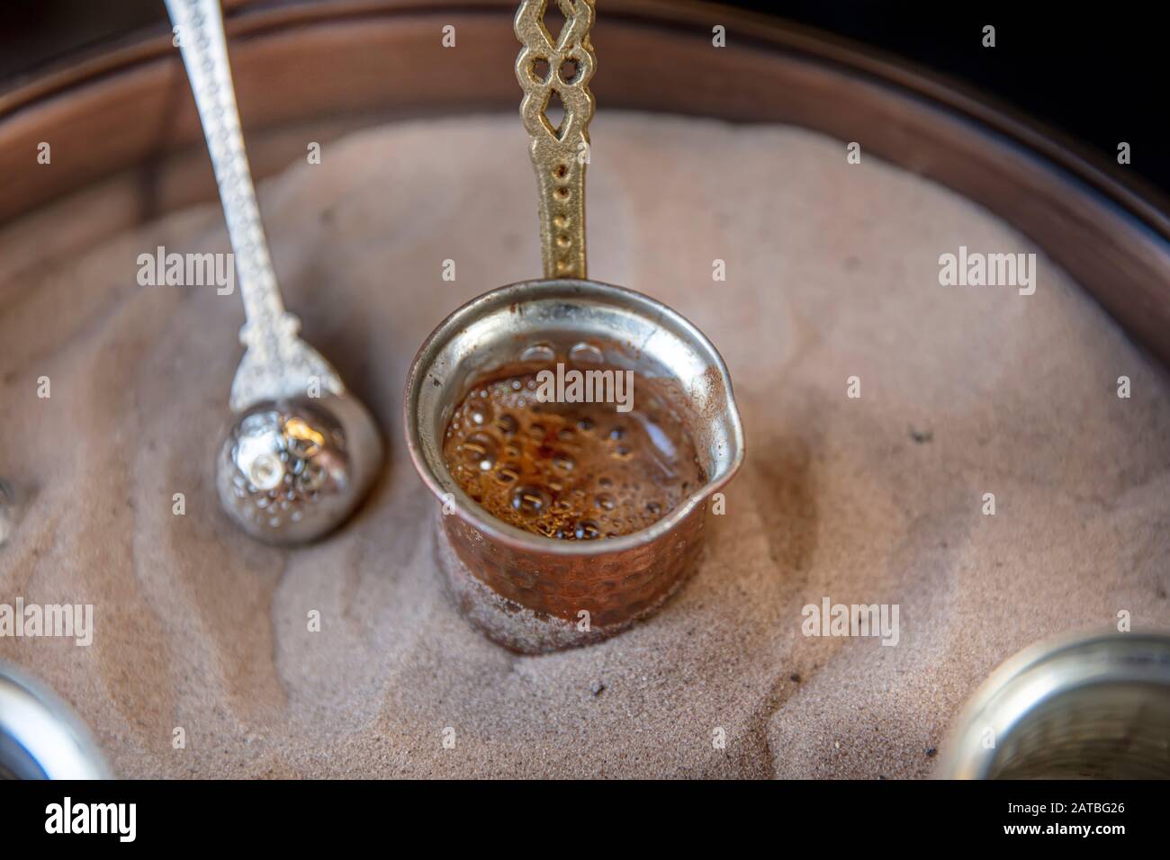 Traditional turkish coffee in cezve prepared on hot sand. Selective ...