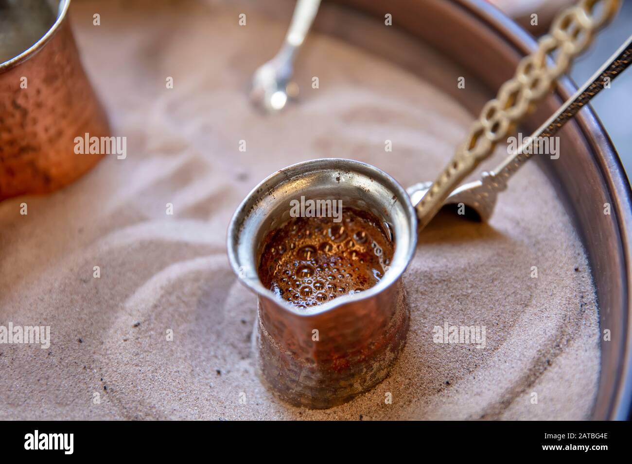 Traditional turkish coffee in cezve prepared on hot sand. Selective ...