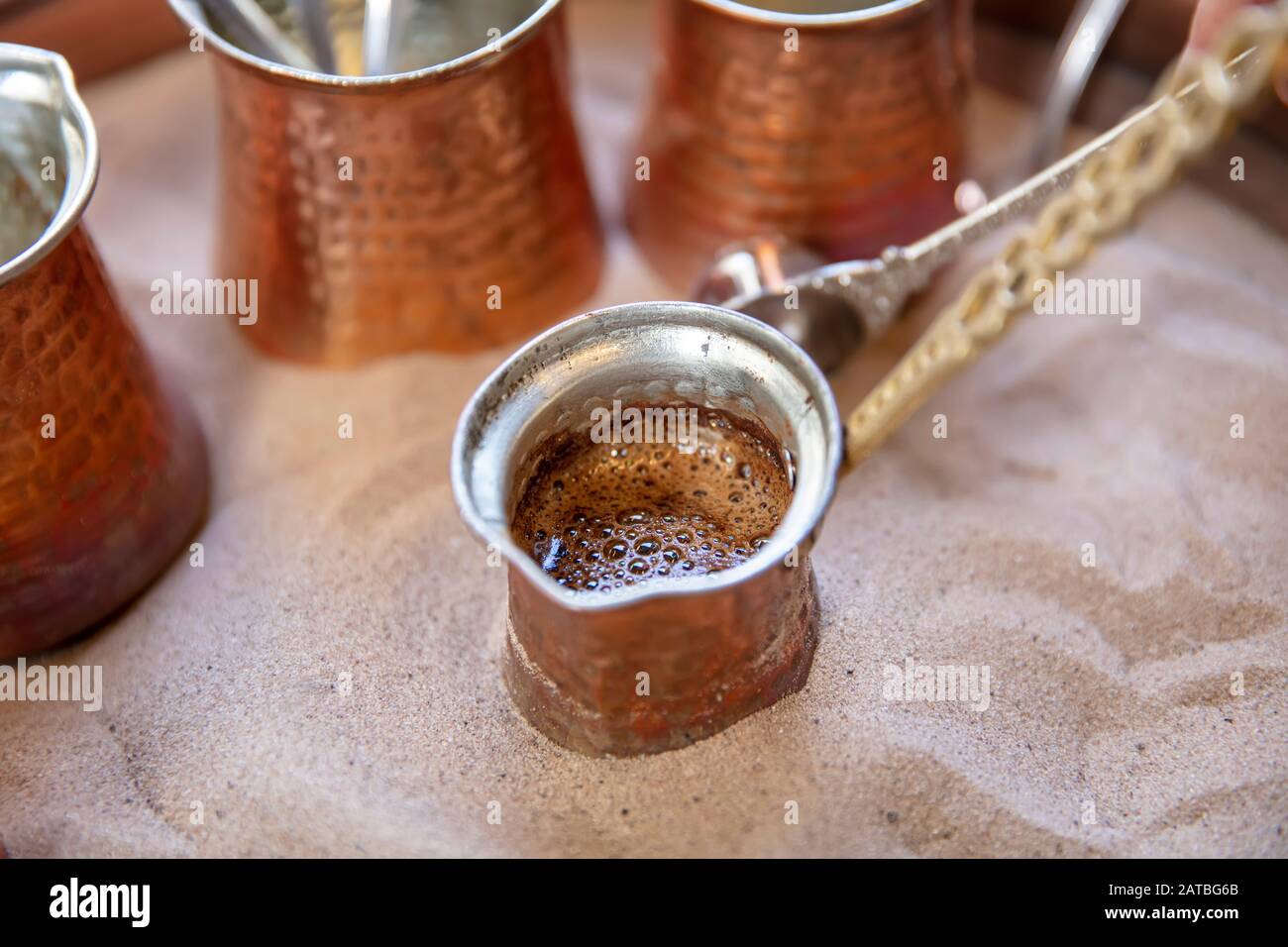 Traditional turkish coffee in cezve prepared on hot sand. Selective ...