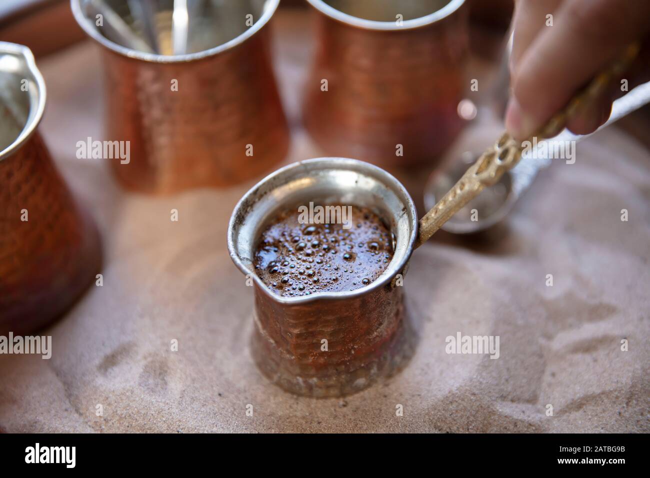 Traditional turkish coffee in cezve prepared on hot sand. Selective ...