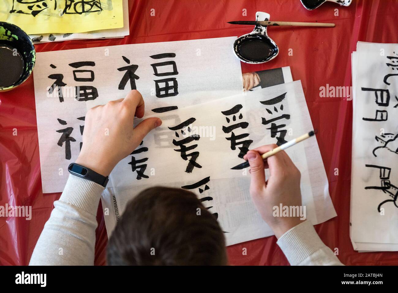 A young man learning to write Chinese characters during Calligraphy ...