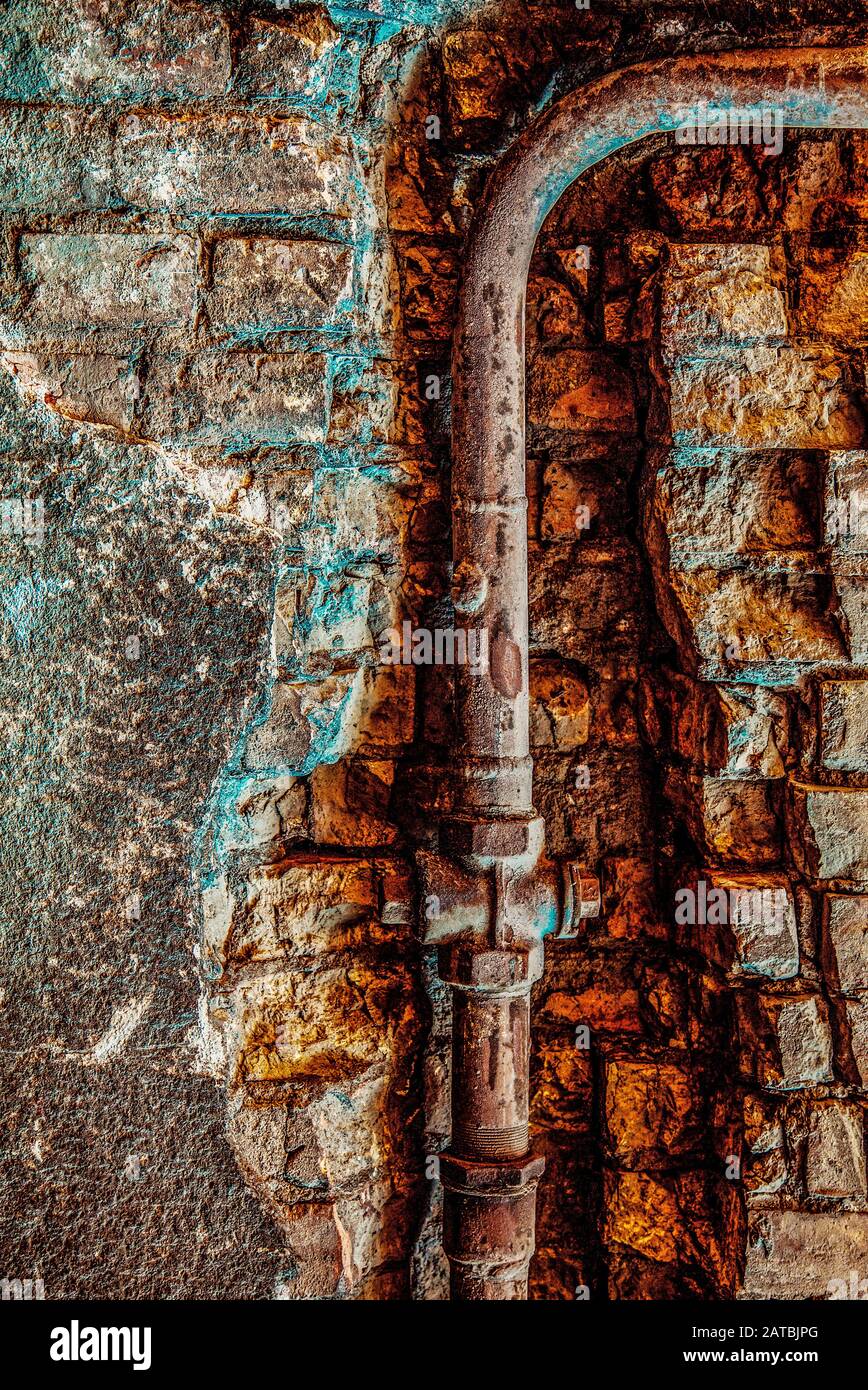 Old rusty water pipe in a brick wall. Old rusty pipe with valves on ...