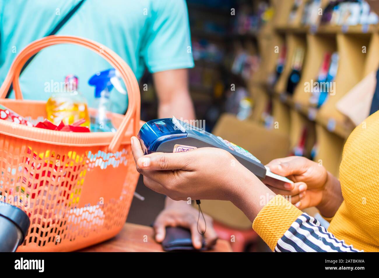 black female merchant using a point of sale machine to accept payment ...