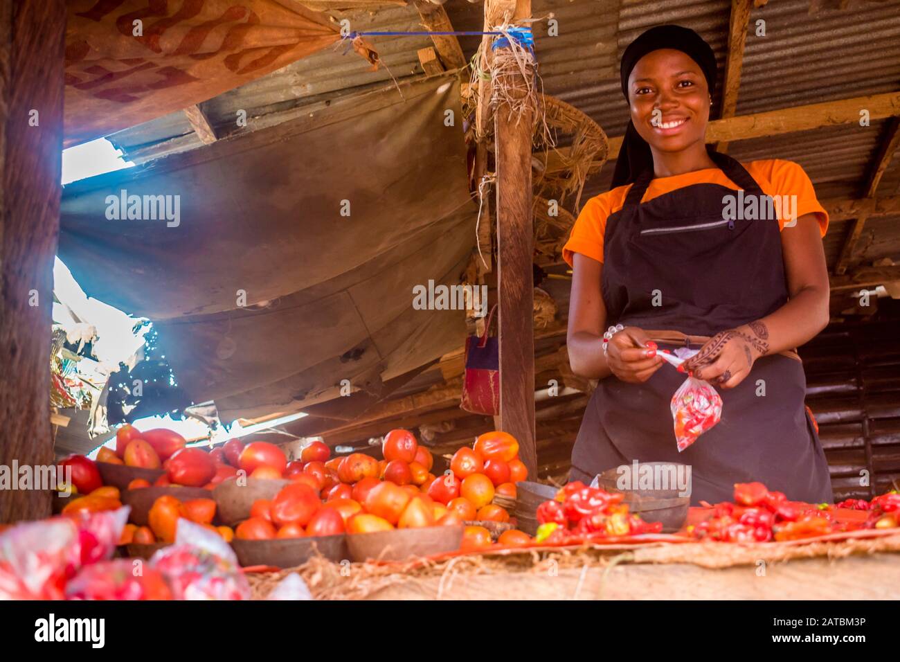 young african woman selling food stuff in a local african market ...