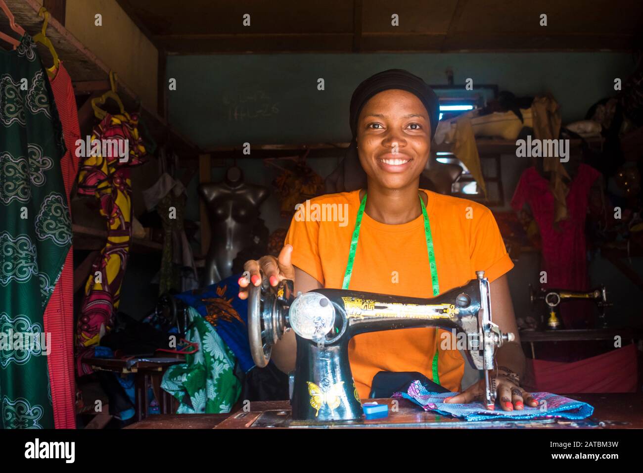 young african woman who is a tailor working on a dress smiling Stock ...