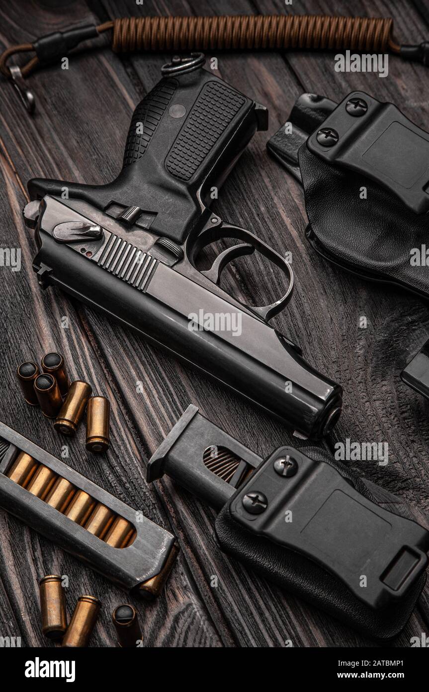 A modern black pistol and ammunition on dark metal background. Weapons ...