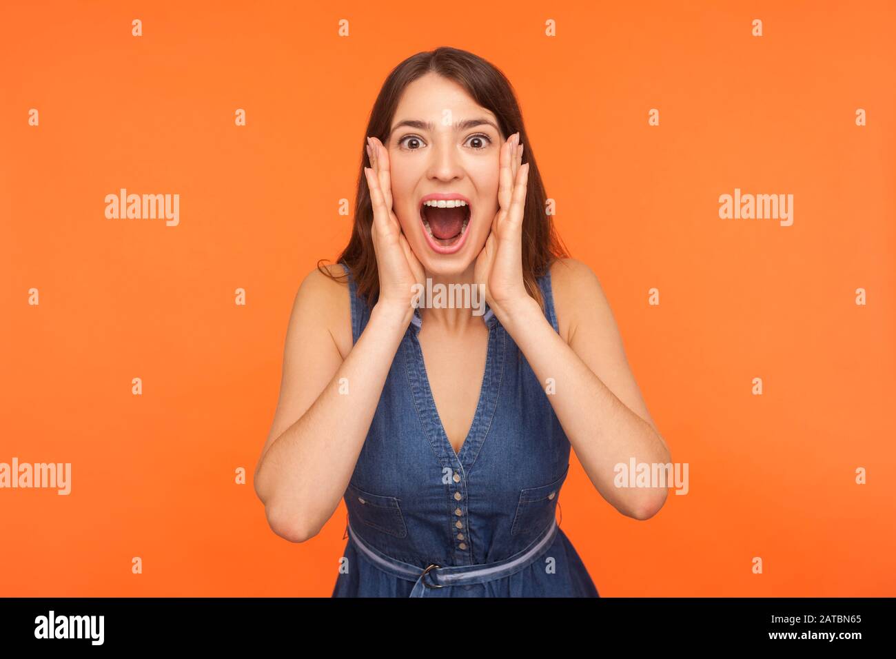 Oh my god, wow! Shocked impressed brunette woman in denim outfit ...