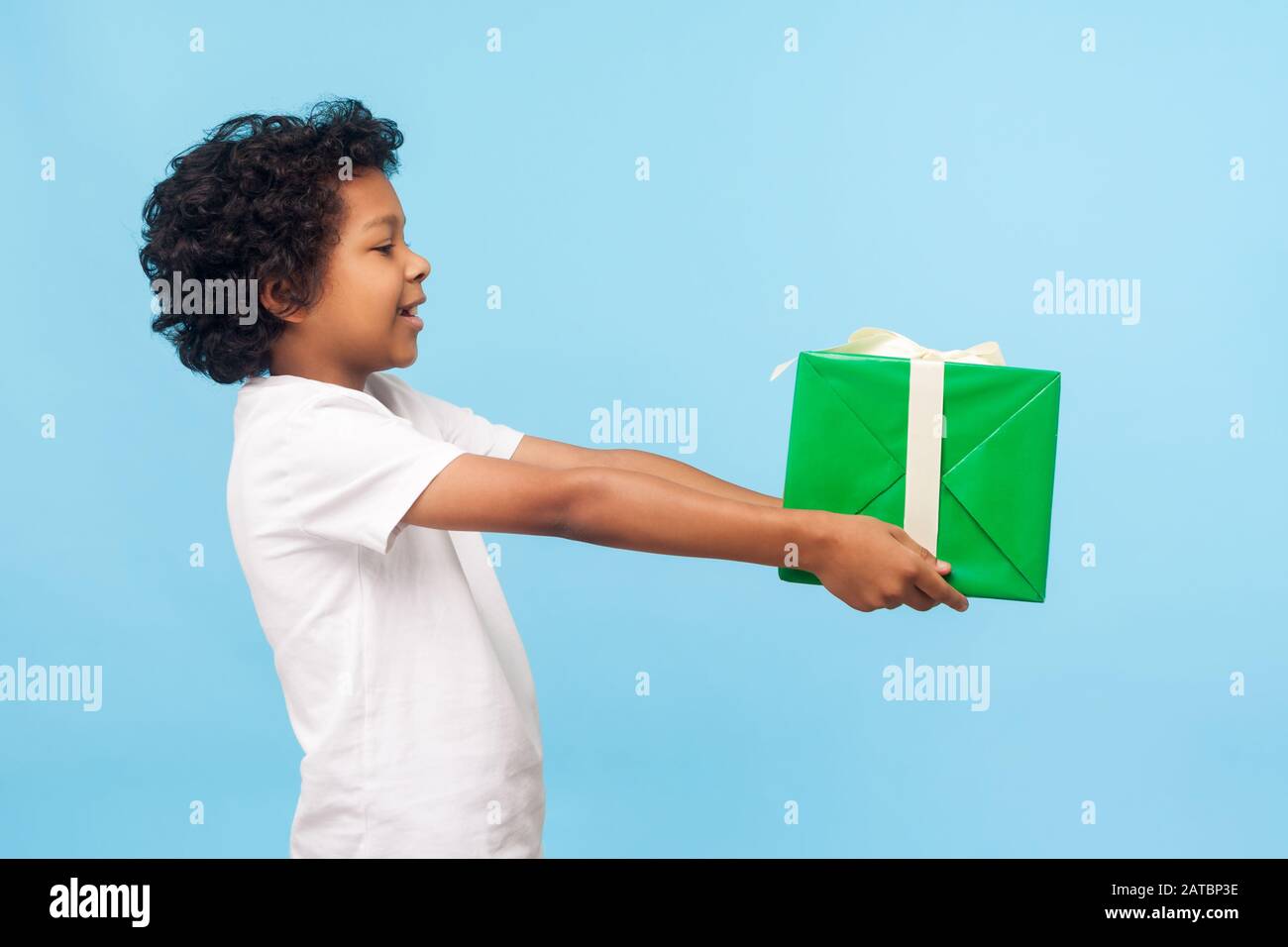 Take this present! Side view of cheerful generous good-natured little ...