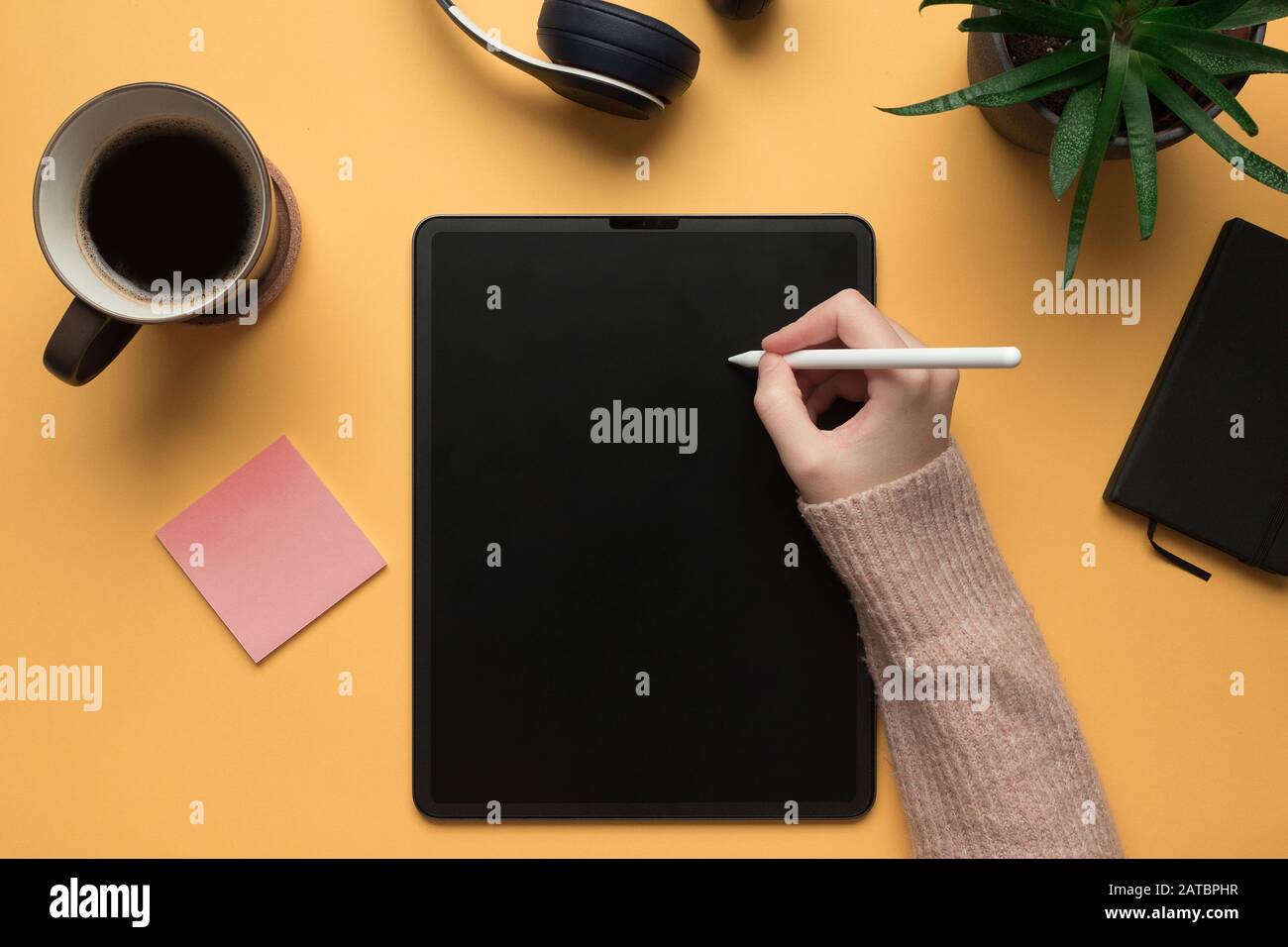 Stock photo of a young woman's hand writing on the screen of a black ...
