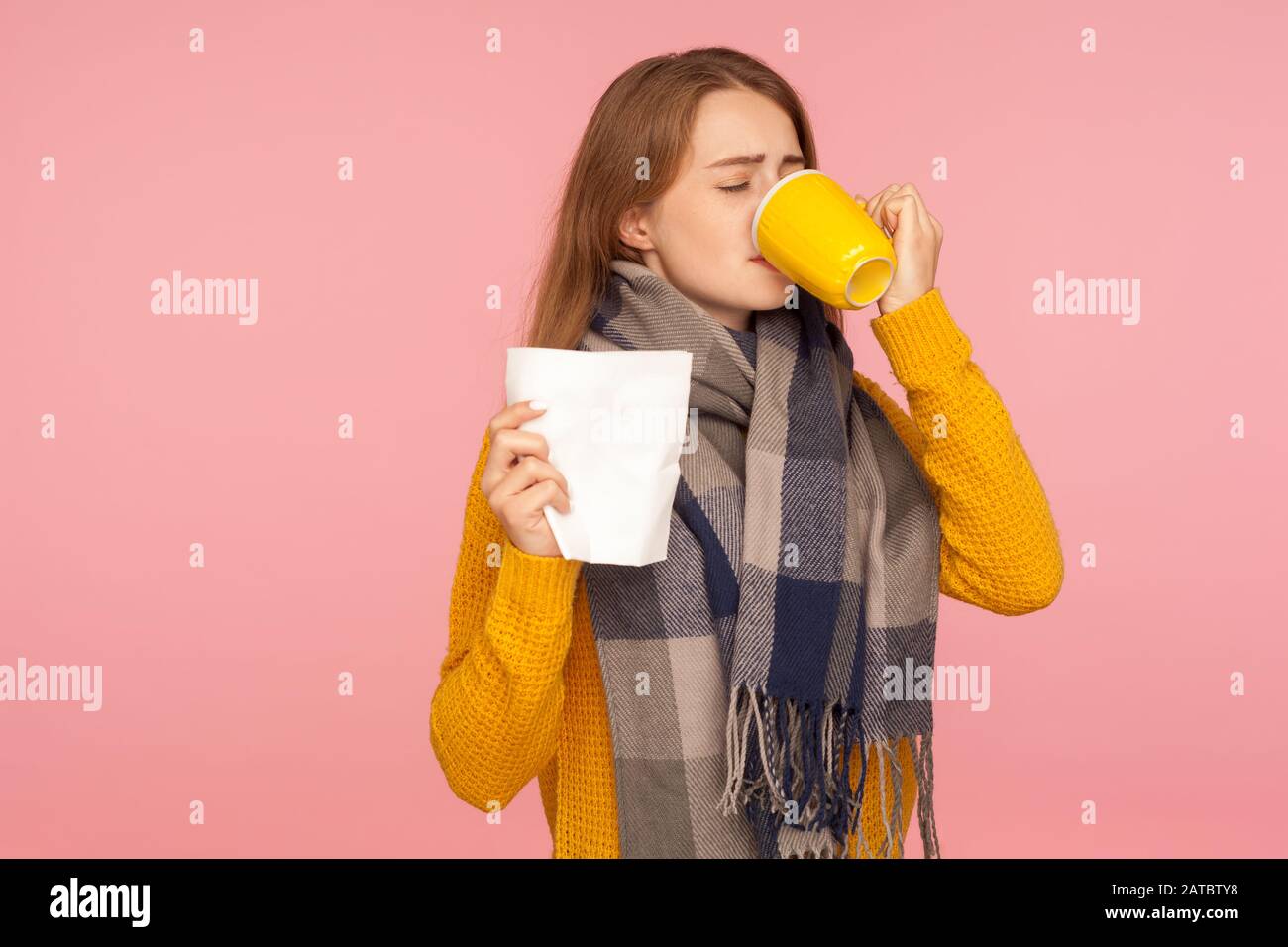 Flu treatment. Portrait of sick ginger girl wearing big scarf, holding ...