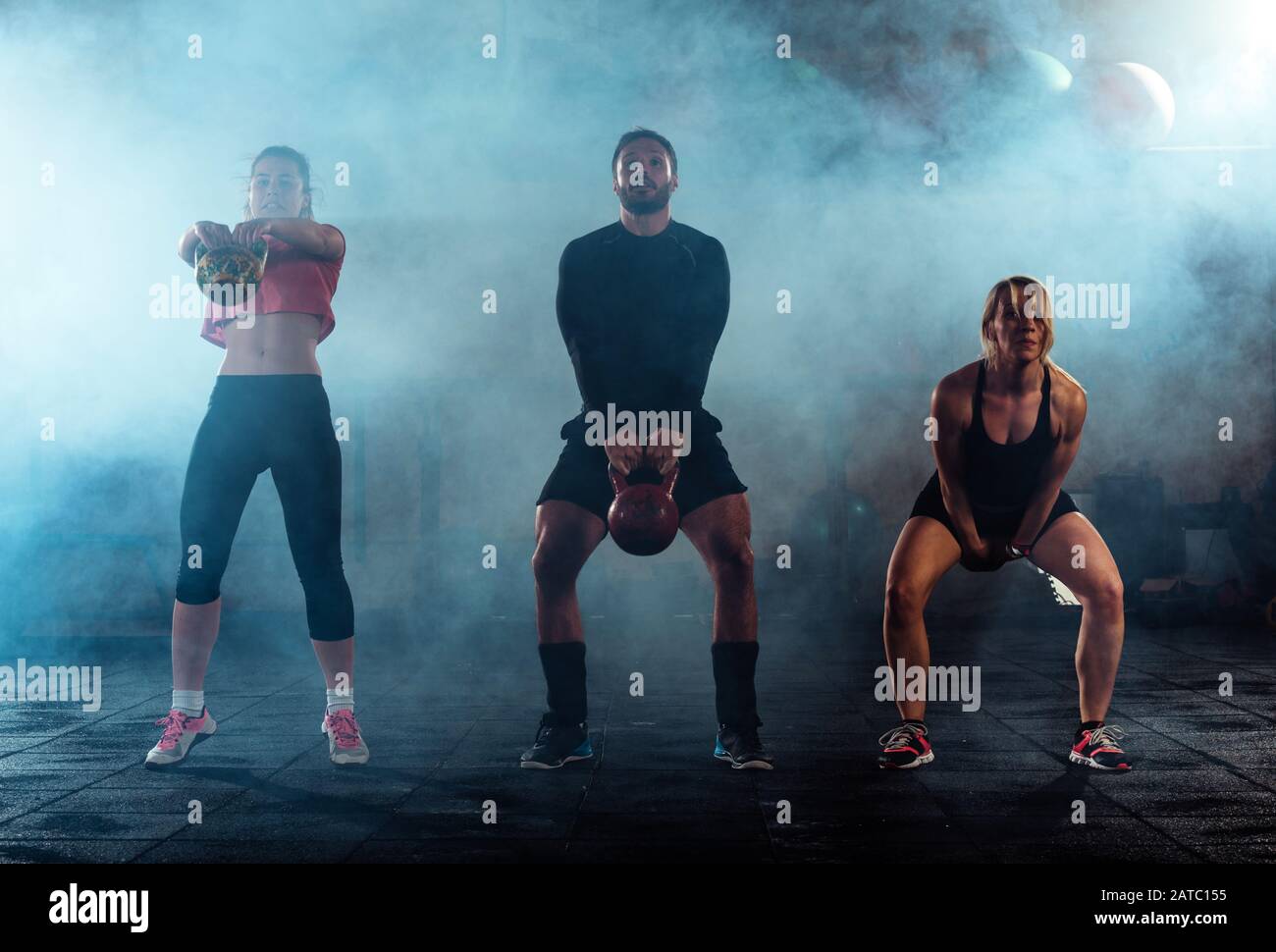 Three caucasian people doing crossfit workout at gym Stock Photo - Alamy