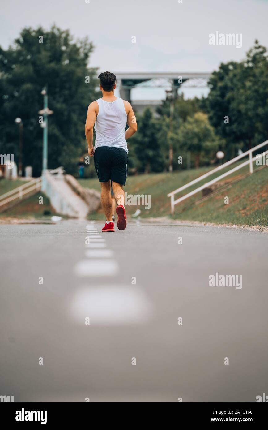 Photo of athlete man running through stadium during spring jog Stock ...