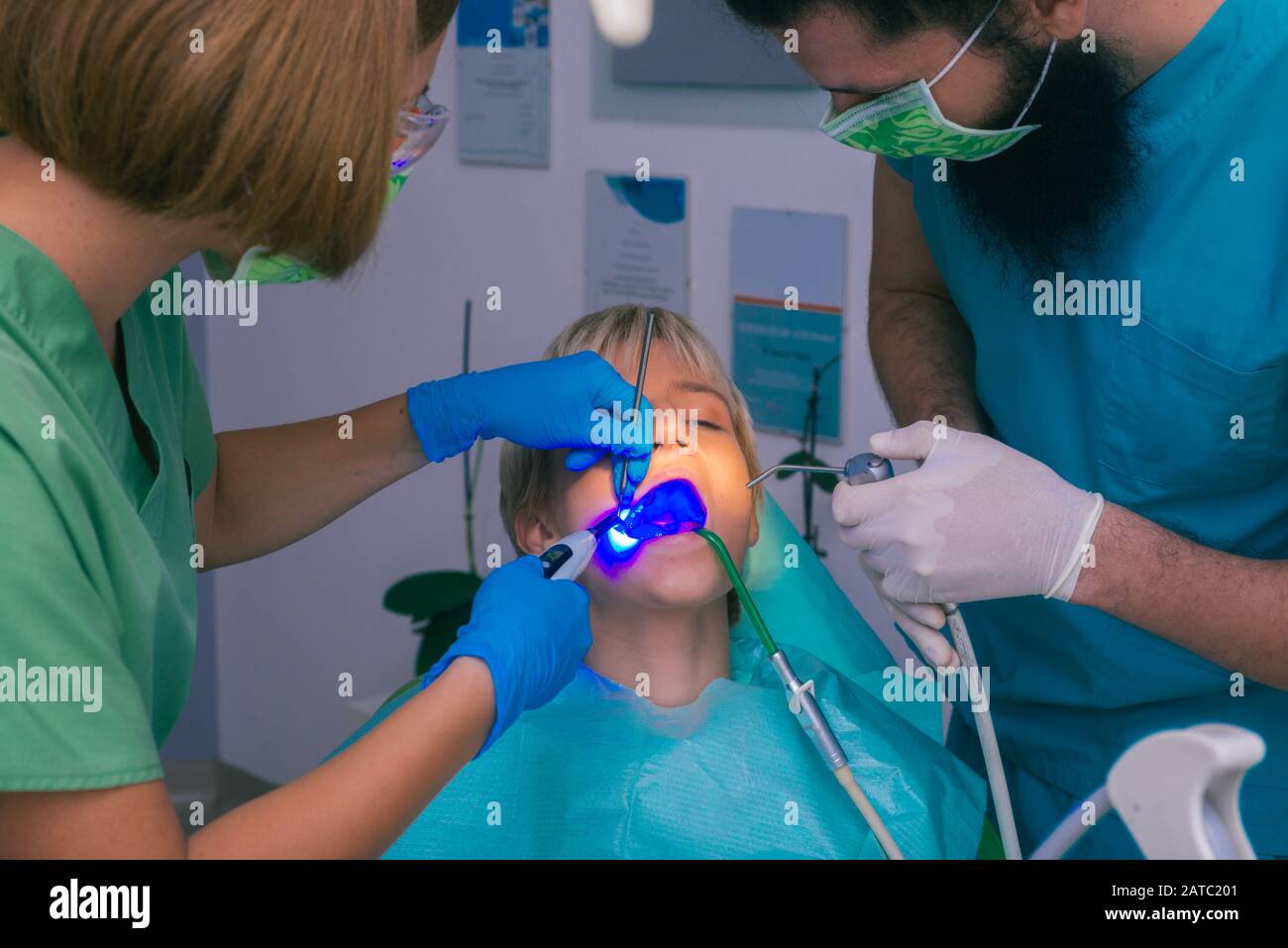 Closeup dental examination with ultraviolet light on a female patient ...