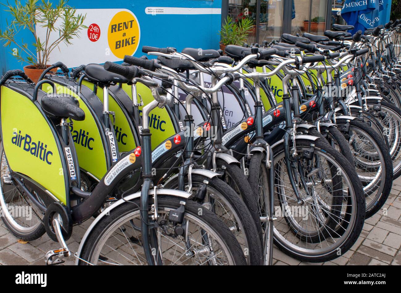 Green rental bicycles with baskets parked on a cobblestone street ...