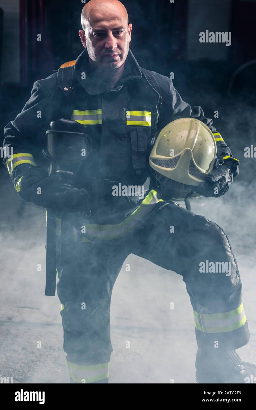Fireman standing confident holding helmet and wearing firefighter ...