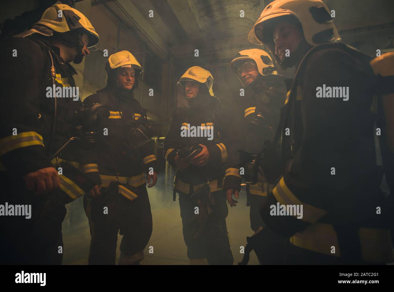 Group of firefighters with uniform inside the fire station preparing ...