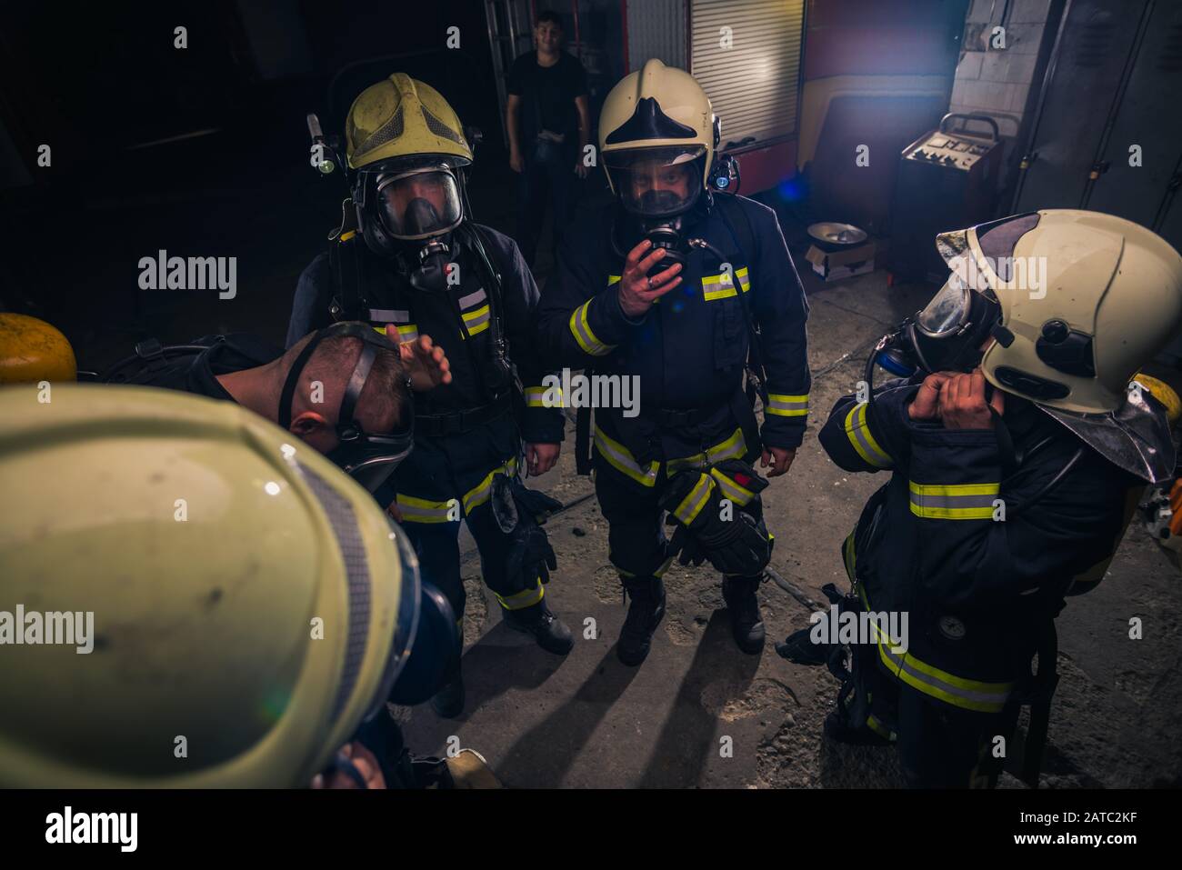 Group of firefighters standing inside the fire brigade wearing helmet ...