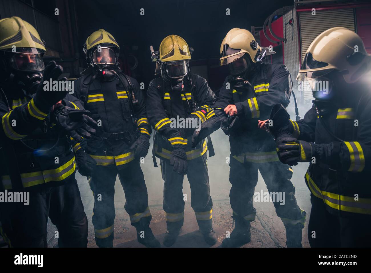 Team of firefighters in the fire department wearing gas masks and ...