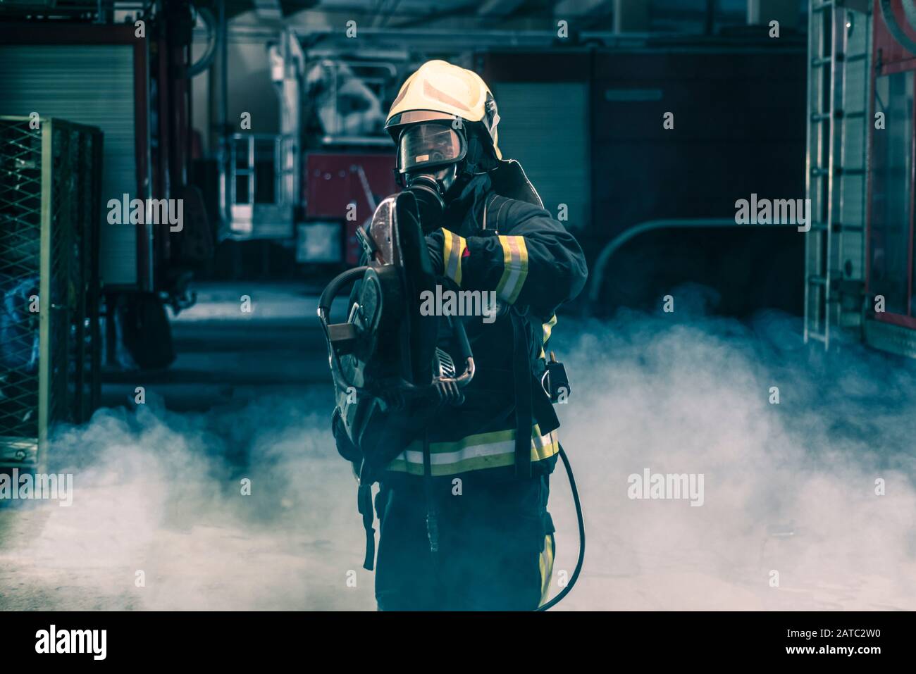 Portrait of a firefighter wearing full protective equipment posing with ...