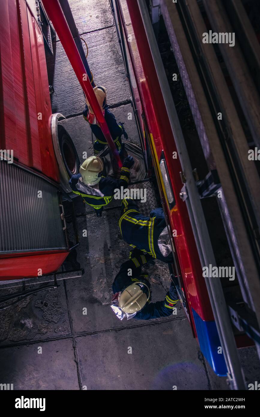 Firemen checking the fire engine inside the fire department from a bird ...