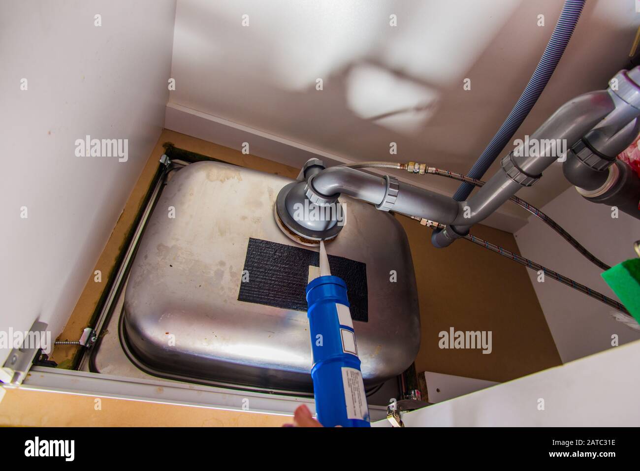 Plumber is working with caulking gun and fixing the basin Stock Photo ...