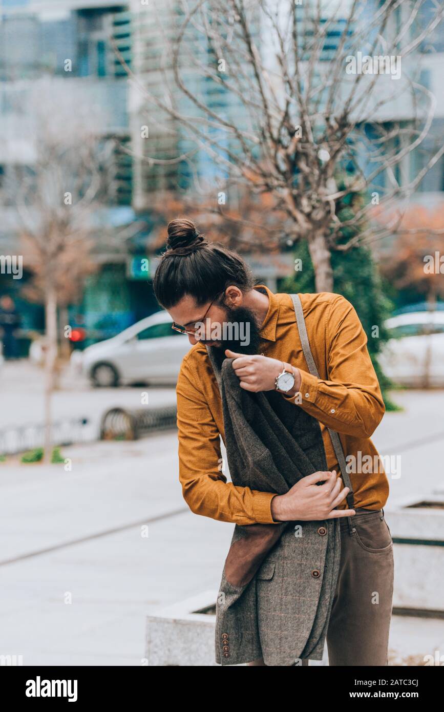 Fashionable male dressed in expensive outfit holding his jacket in an ...