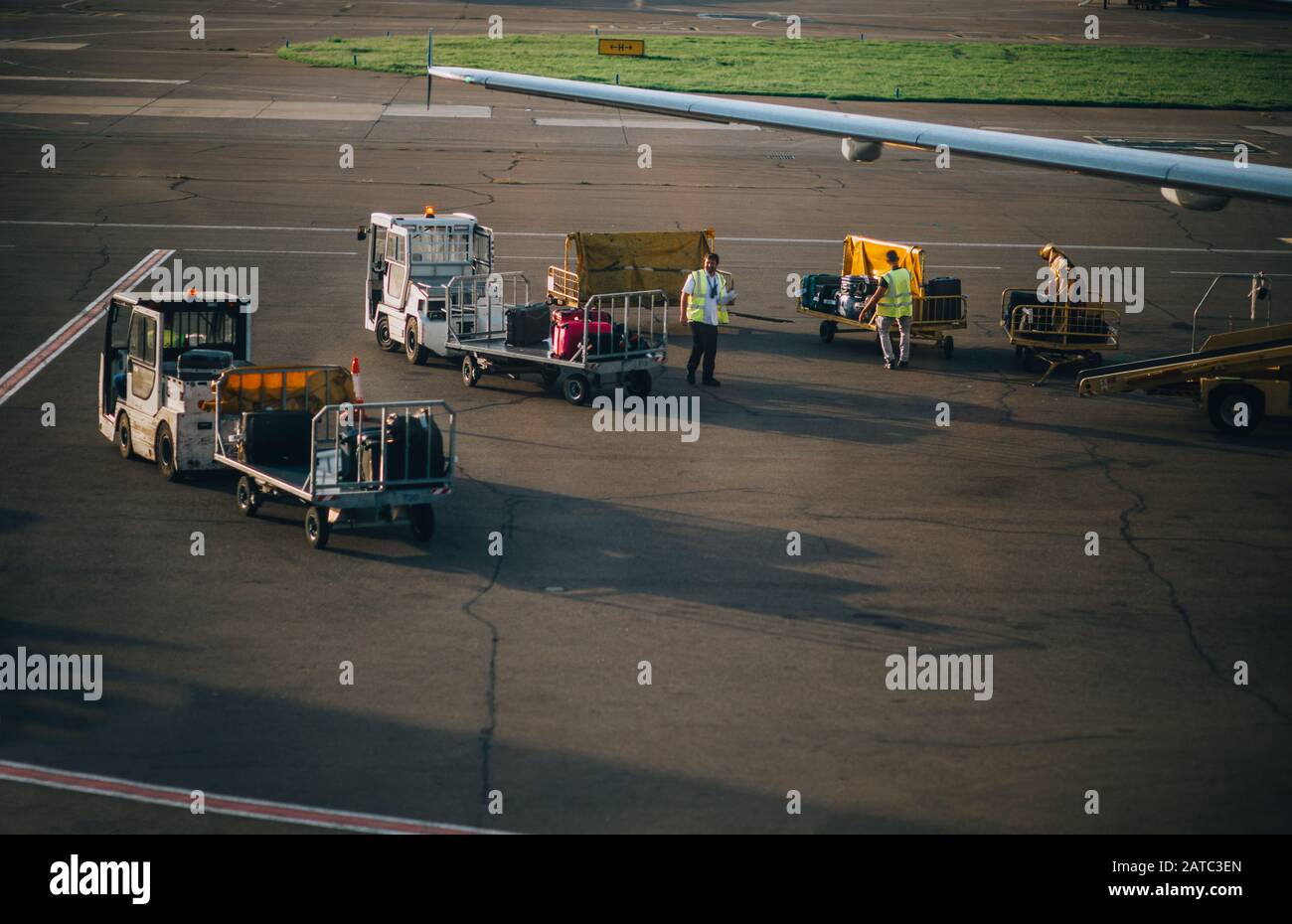 Ground support vehicles transporting passenger luggage at an aerodrome ...
