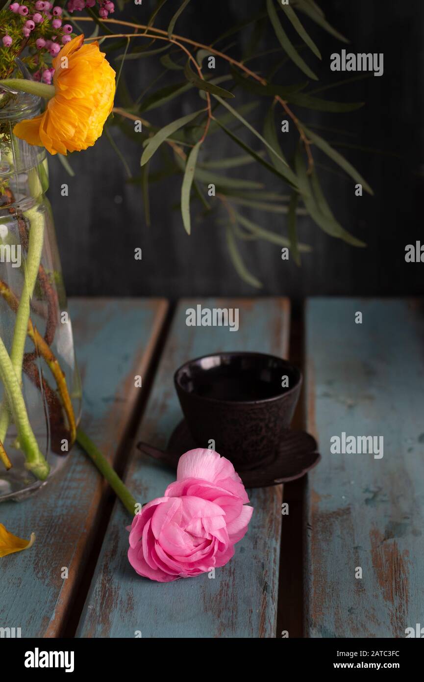 Coffee scene with a ping buttercup in the front Stock Photo - Alamy