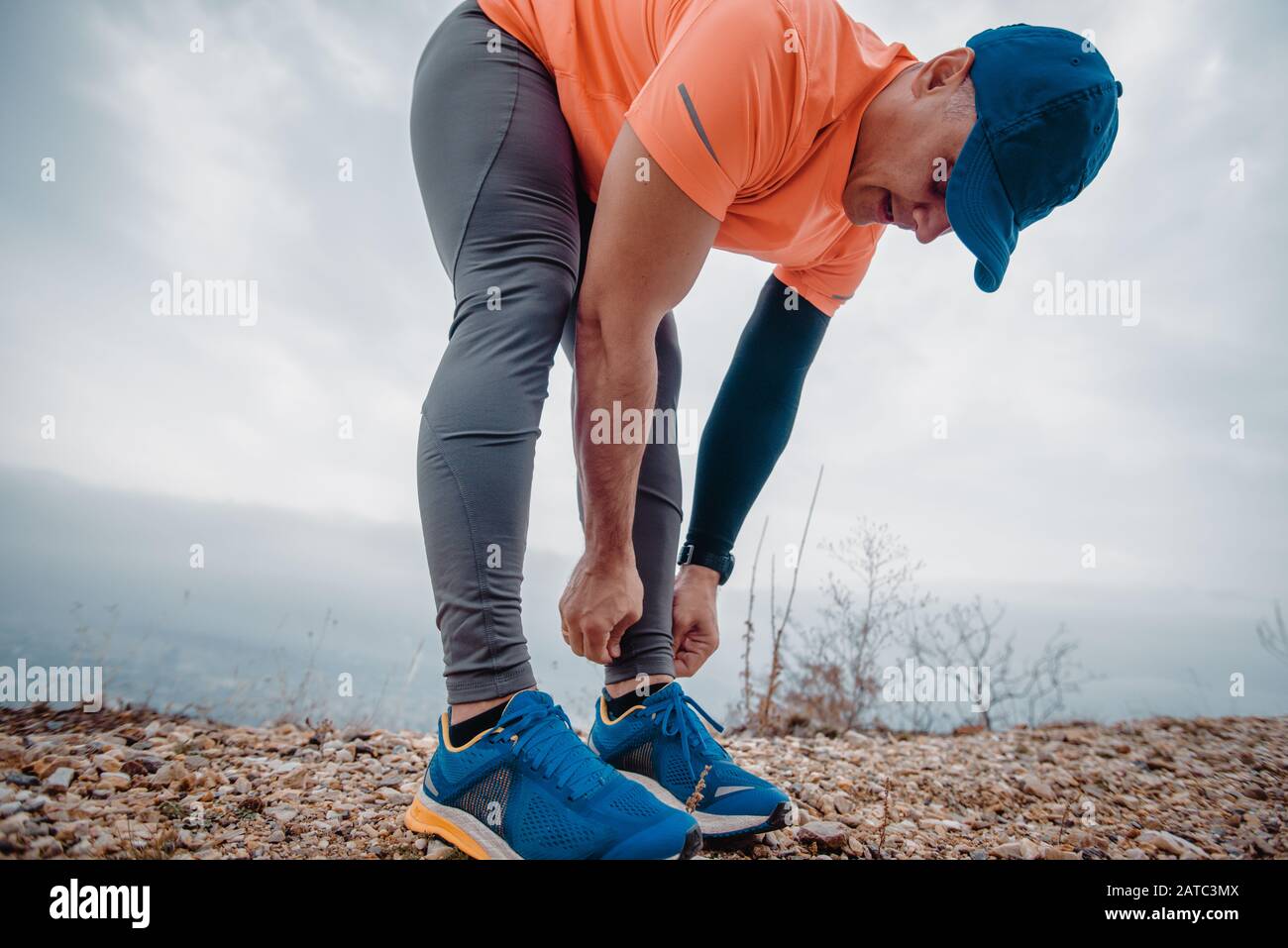 Muscular man wearing sport clothes during preparation for running ...