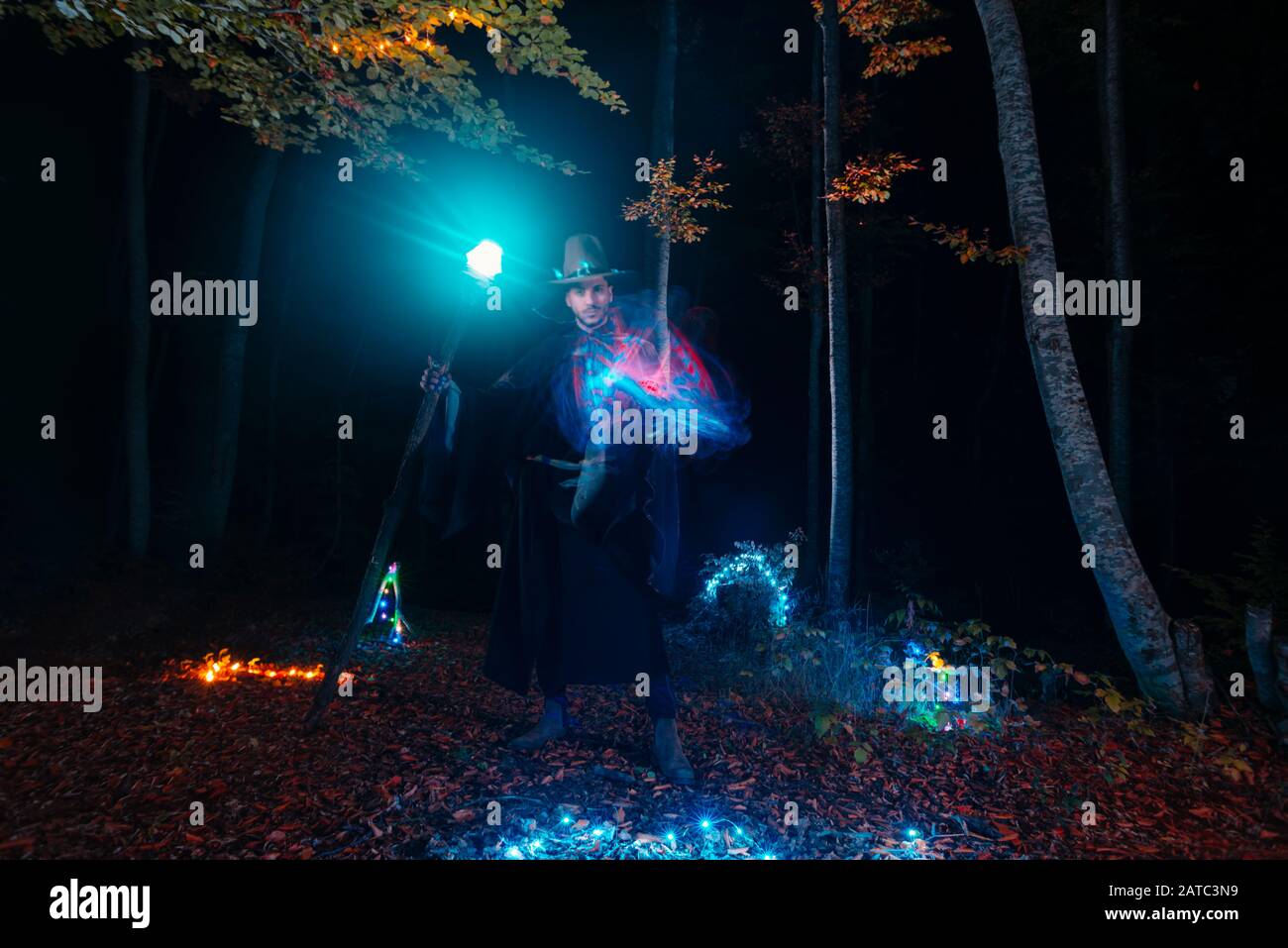 Sorcerer (magician) casting a spell while standing in the magical woods ...