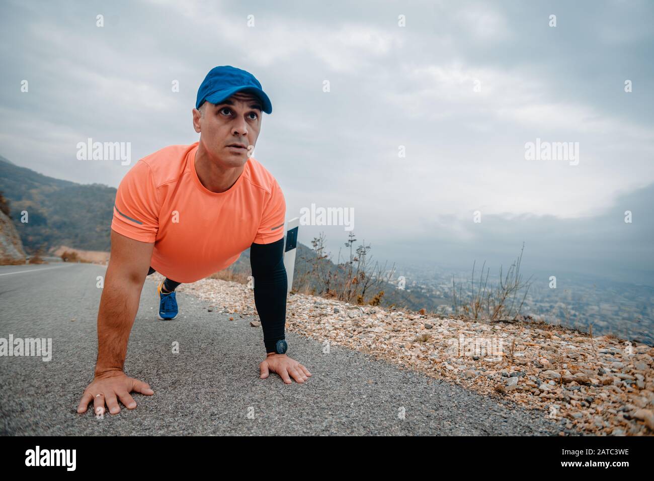 Muscular man wearing sport clothes during preparation for running ...