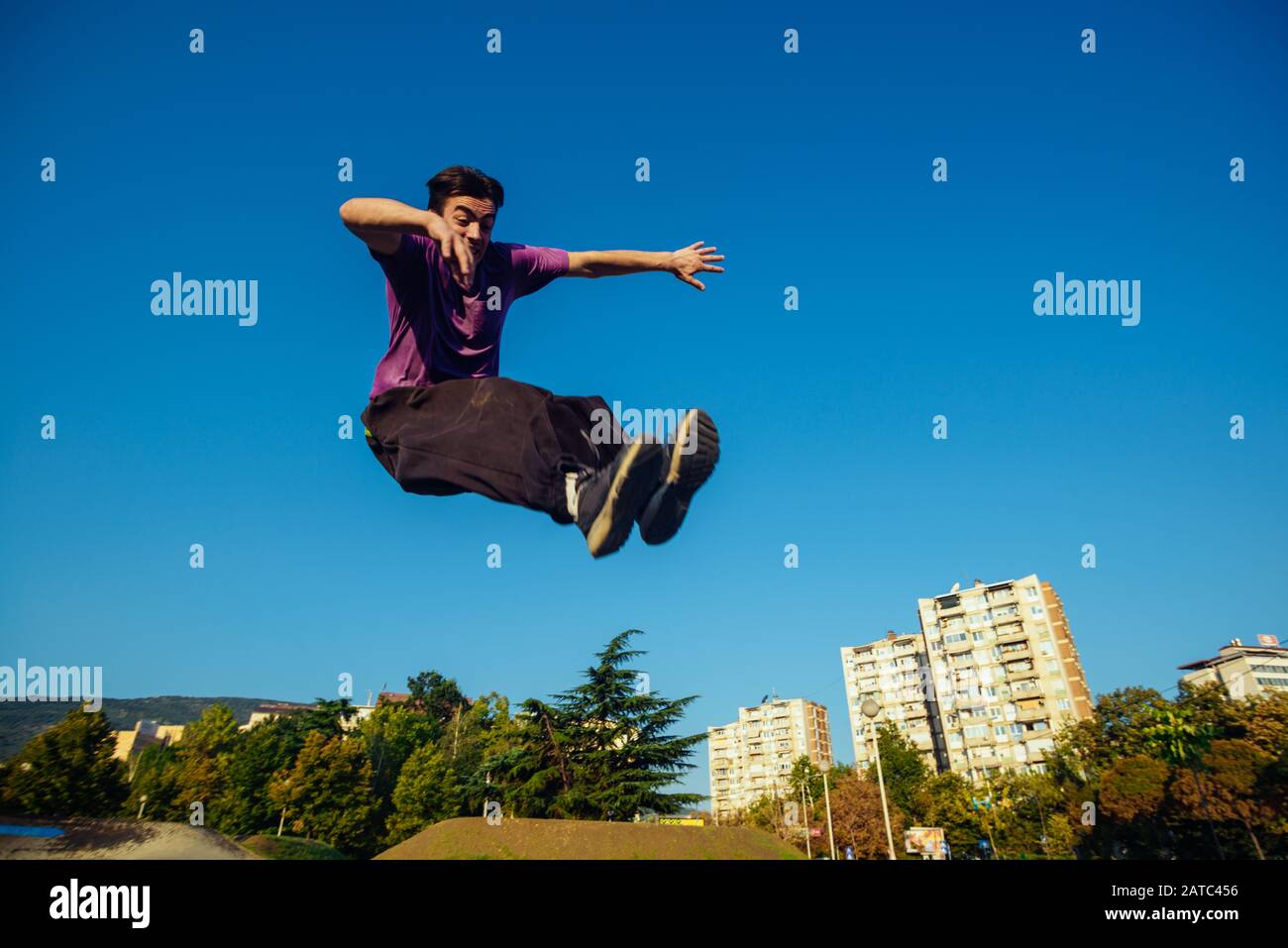 Young man training parkour exercises at the local skatepark Stock Photo ...