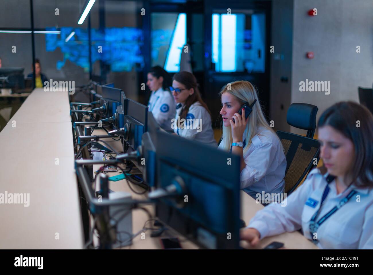 Happy security data center operator colleagues (coworkers) smiling and ...
