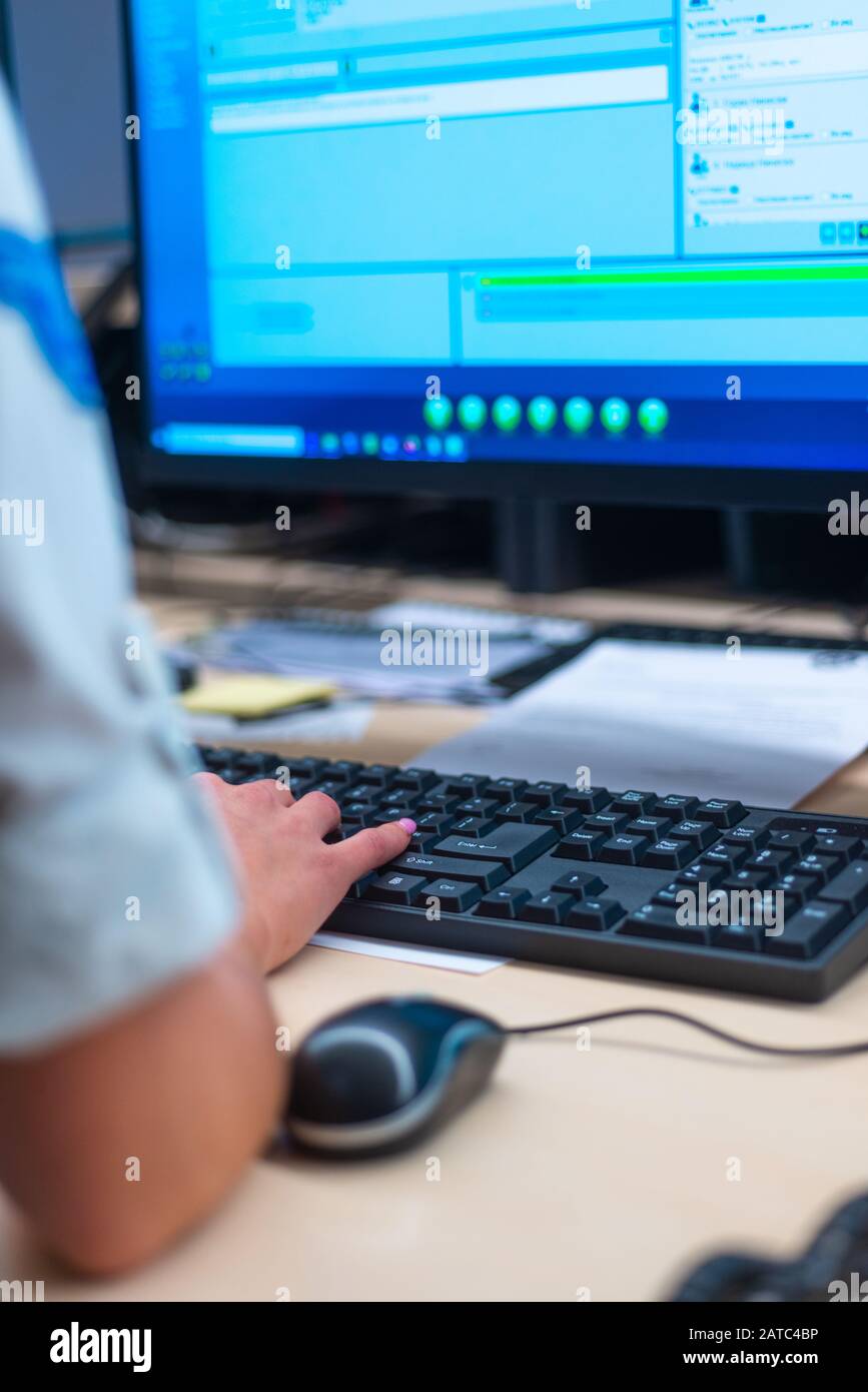 Close up photo of a security data center operator (agent )typing on her ...