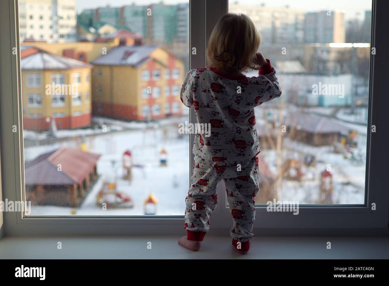 A little girl standing in front of a window Stock Photo - Alamy