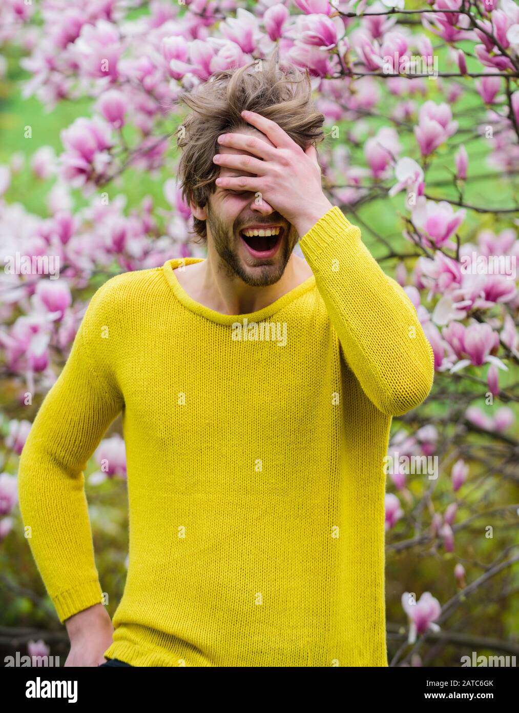 Springtime concept. Unshaven man sniff bloom of magnolia. Man flowers ...