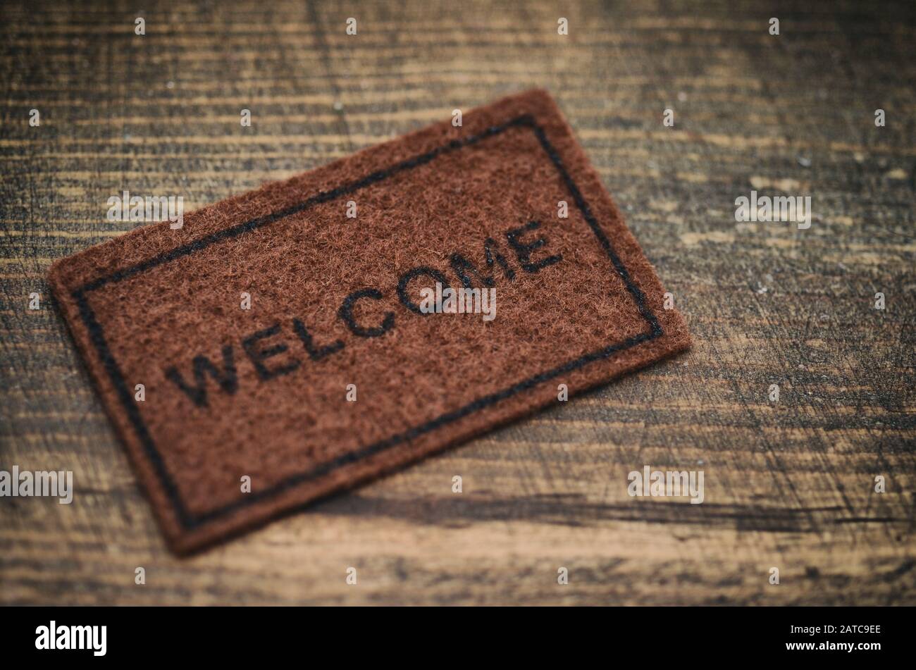 Old Welcome door mat on wooden background, welcome concept, home ...