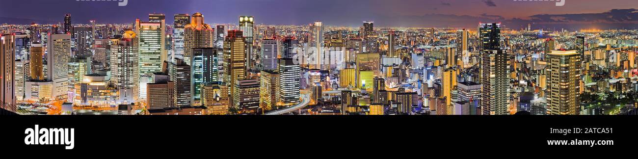 Tops of tall skyscraper towers in Osaka city at sunrise - wide panorama ...