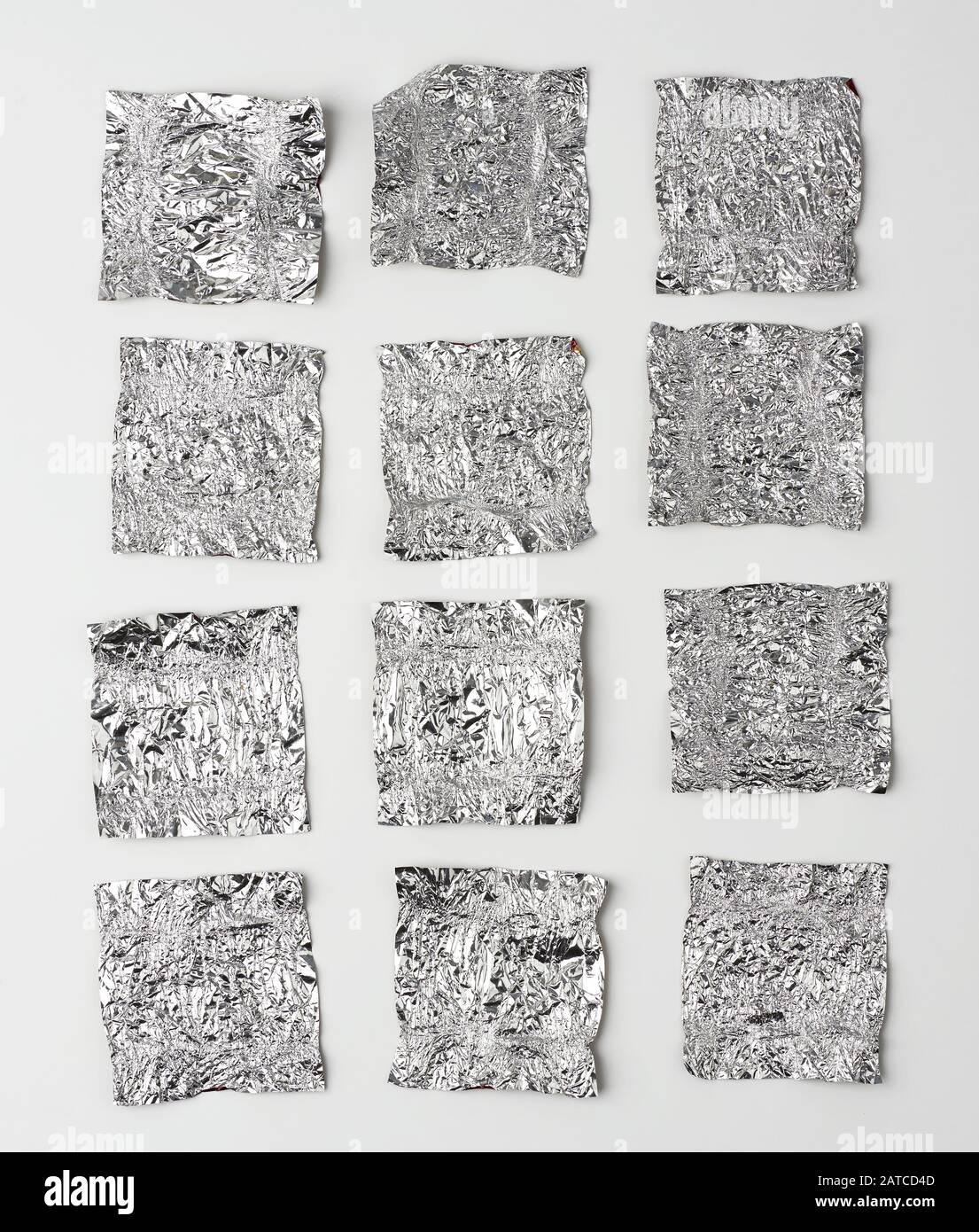 various crumpled foil used candy wrappers on a white background, top ...