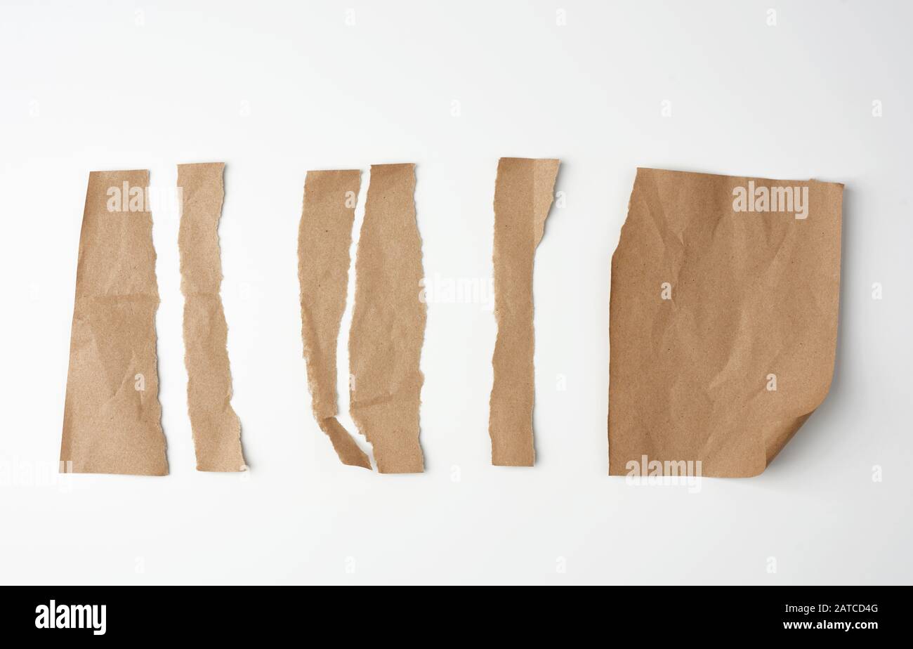 torn brown pieces of parchment paper on a white background, flat lay ...