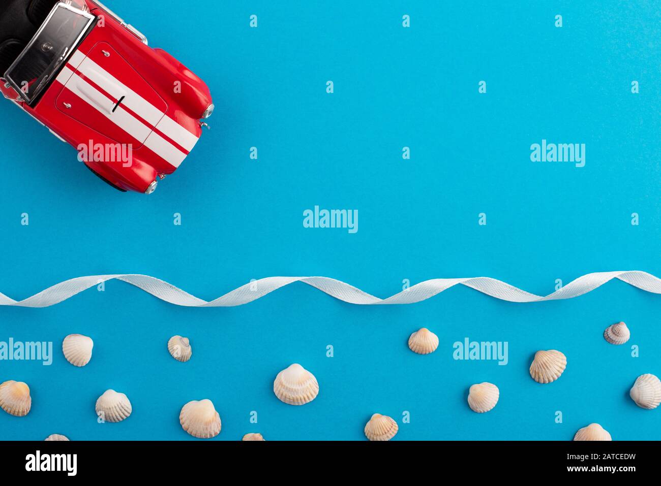 Travel background. Shells, ribbon wave and red car on a blue background ...