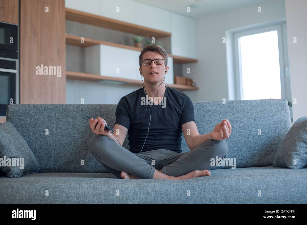 man relaxing to his favorite music, sitting in the Lotus position Stock ...