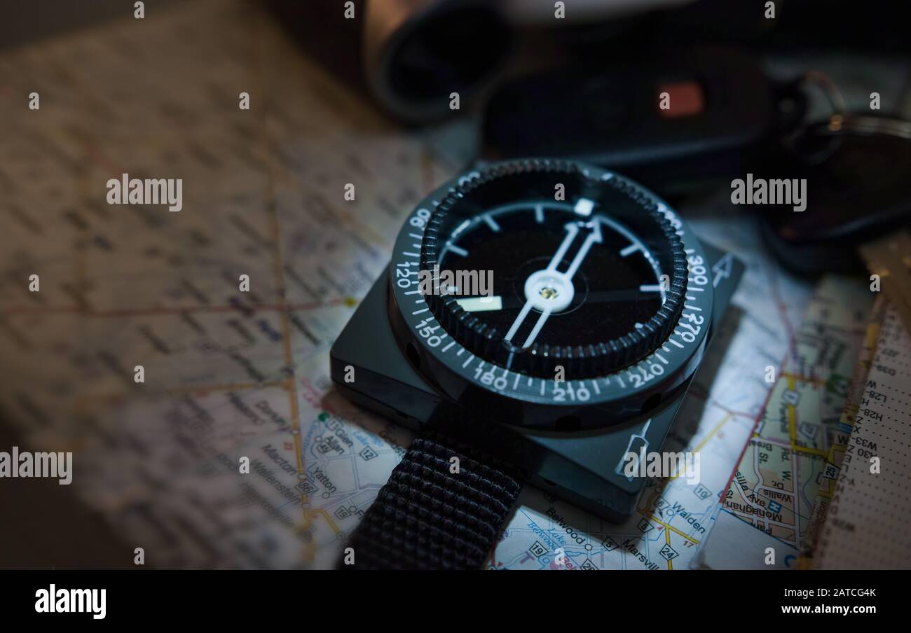A view of a bracelet compass on a map. The night Stock Photo - Alamy
