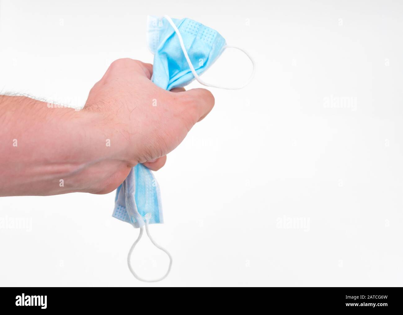 Mans hand hold Blue medical mask isolated on light grey background ...