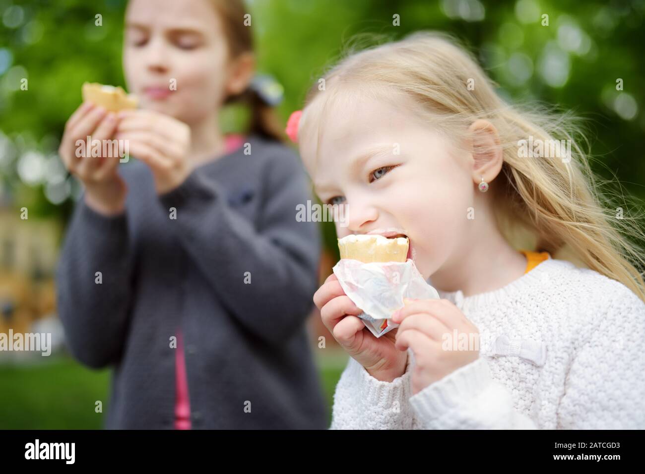 Cute little children eating tasty fresh ice cream in outdoor cafe. Kids ...
