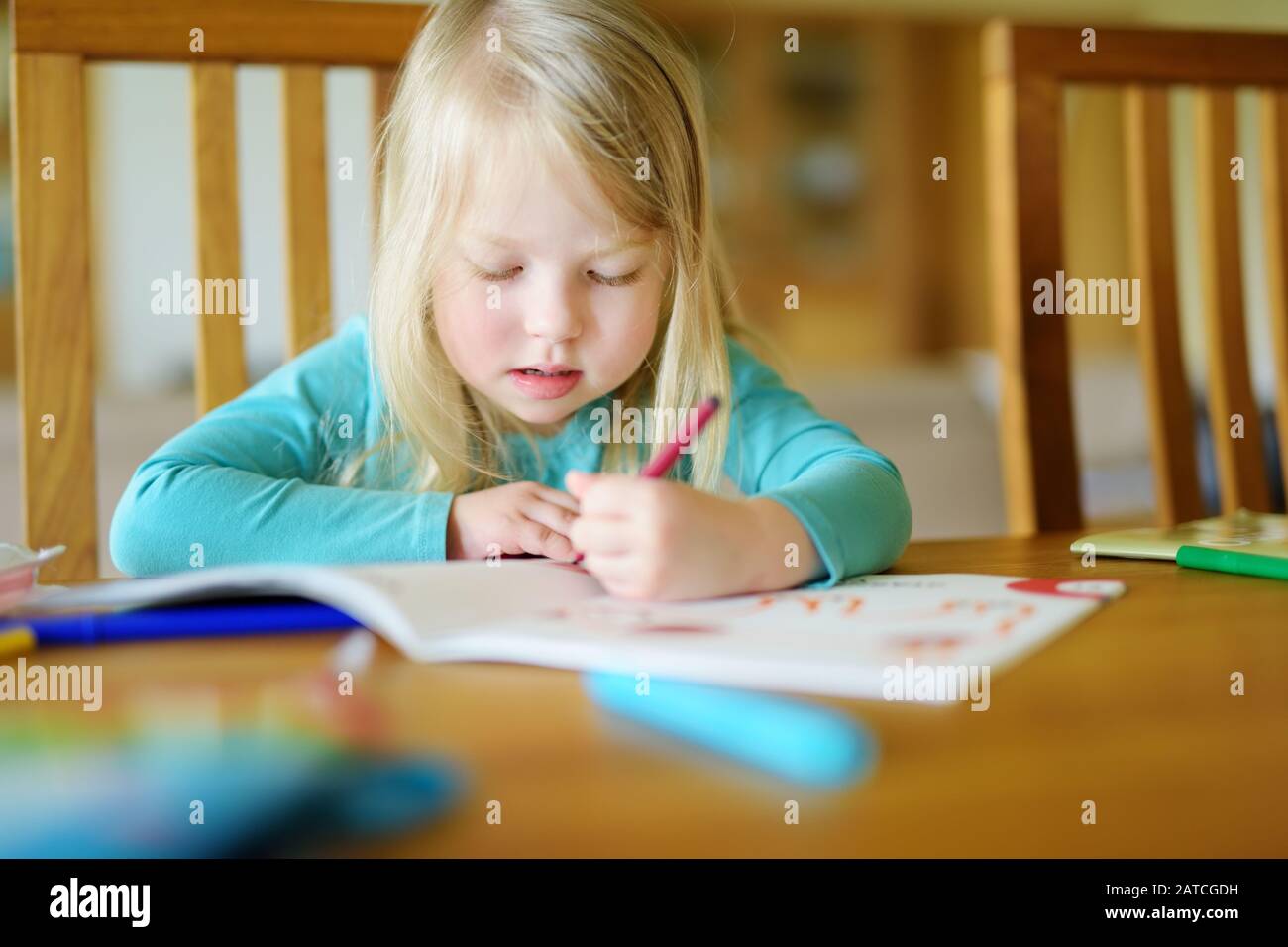 Cute little girl drawing with colorful pencils at a daycare. Creative ...