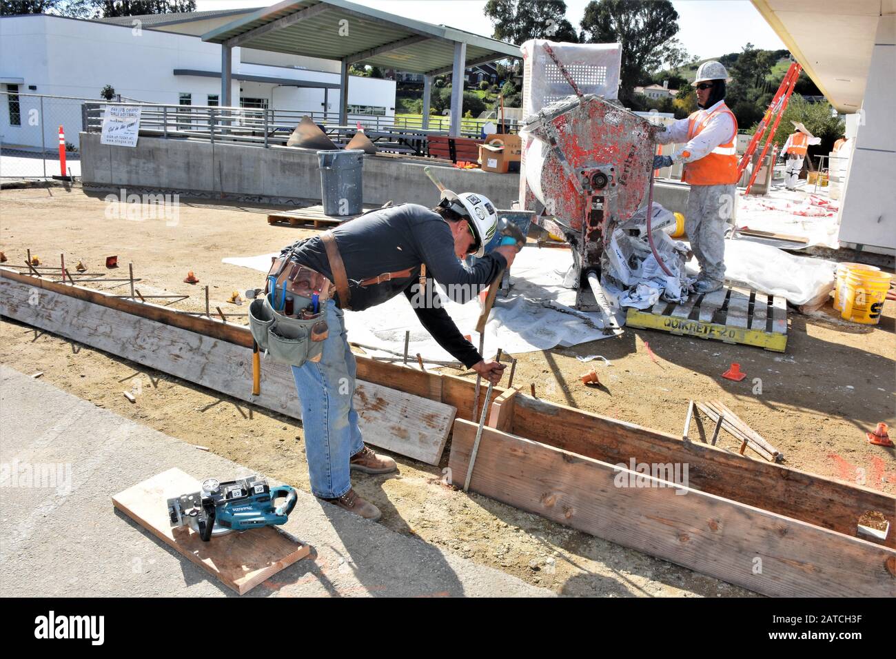 Workers putting in forms for cement curbing at public school in San ...
